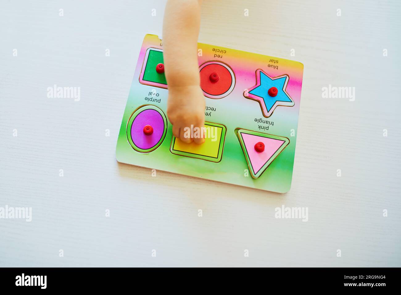Toddler girl or boy doing wooden puzzle. Child learning geometric ...