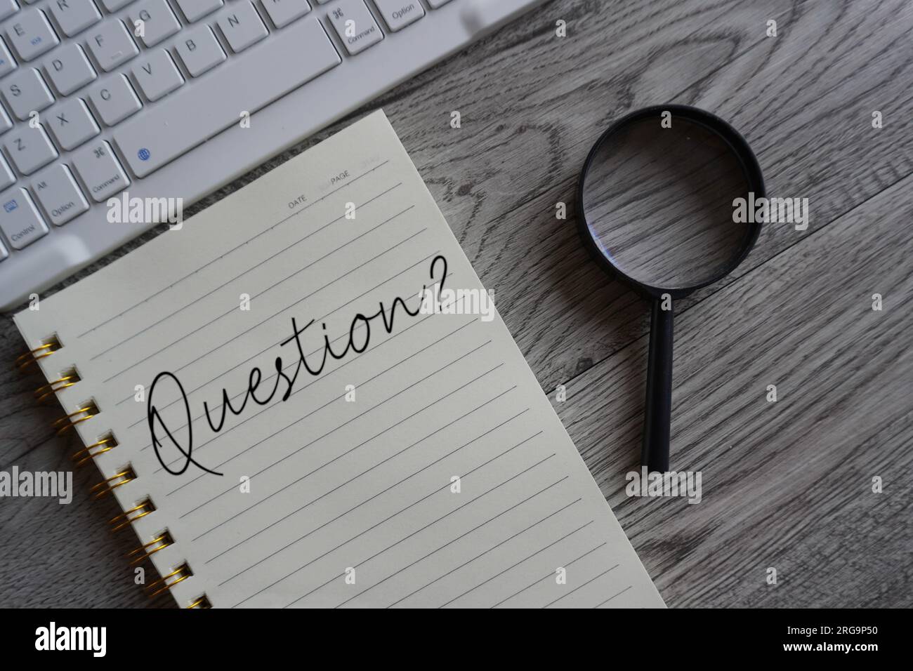 FAQ, Q and A background concept. Close up image of keyboard, magnifying glass and notebook with ...