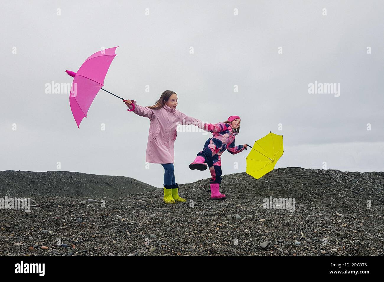 Kid playing out in the rain. Children with colorful umbrella and rain ...