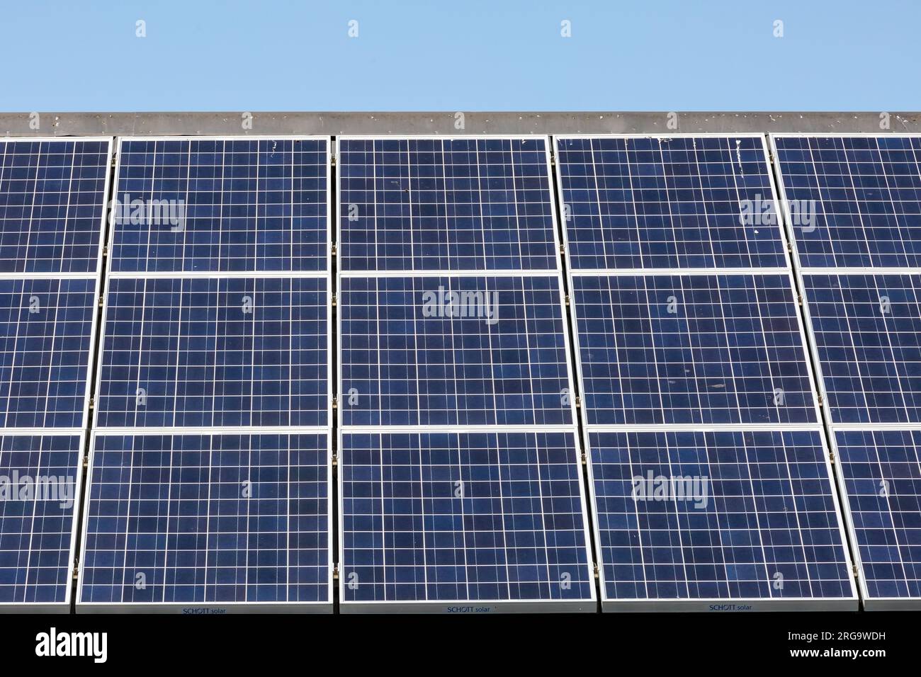 Solar panels on a rooftop, with a blue sky overhead Stock Photo - Alamy