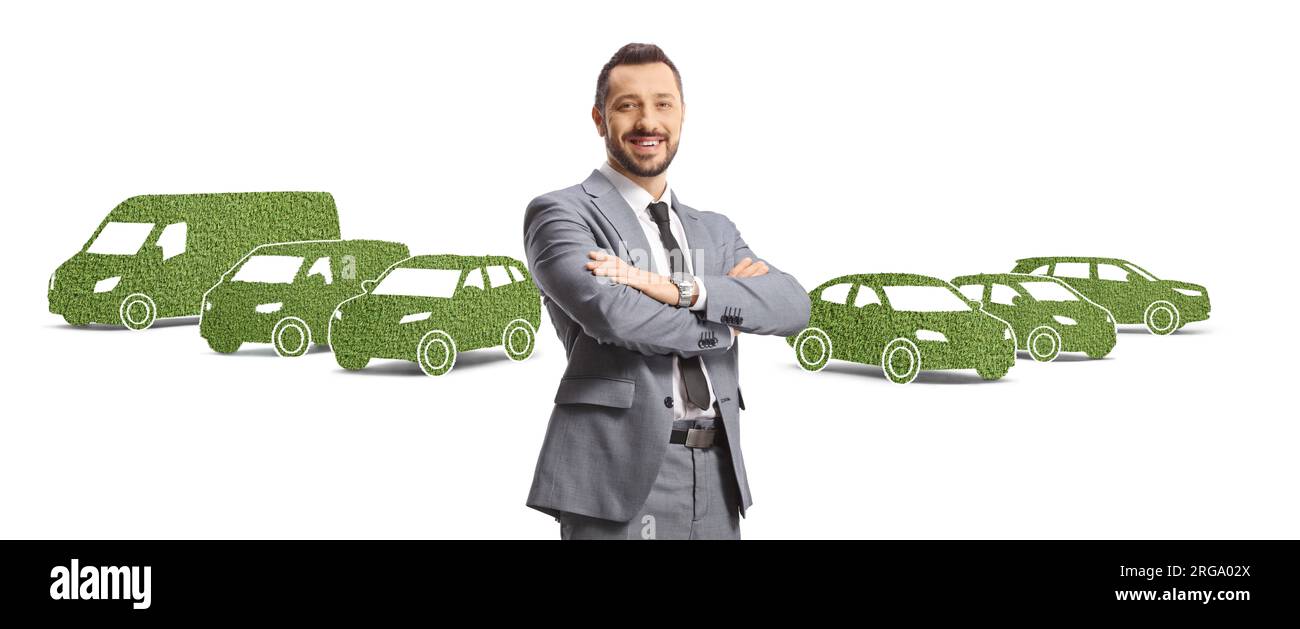 Businessman in front of green electric vehicles standing with folded ...