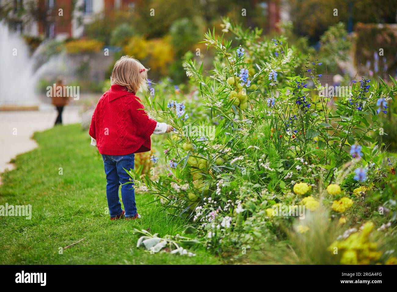 Adorable toddler girl playing in autumn park. Happy kid enjoying fall ...