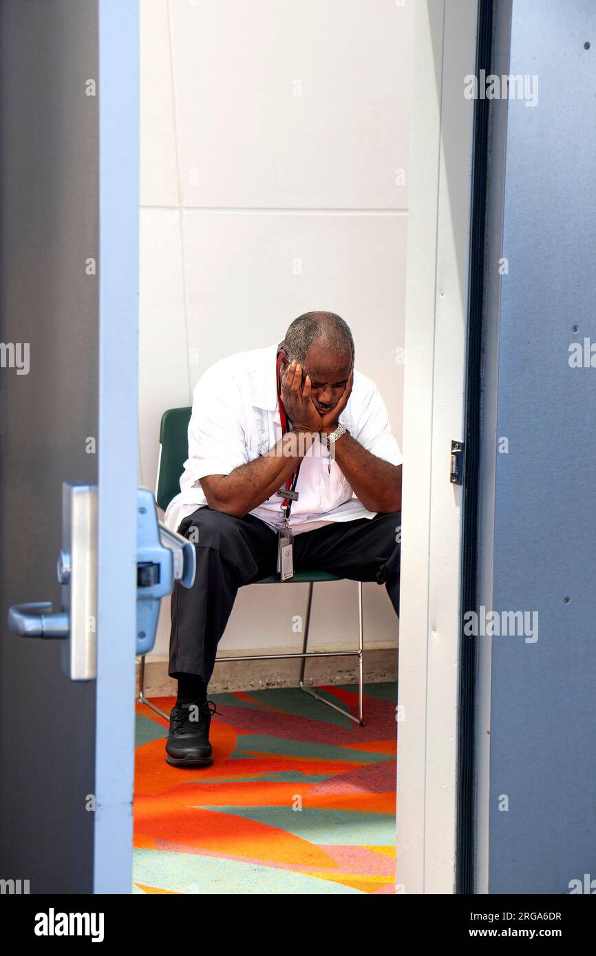 african american security guard in uniform holding head in hands ...