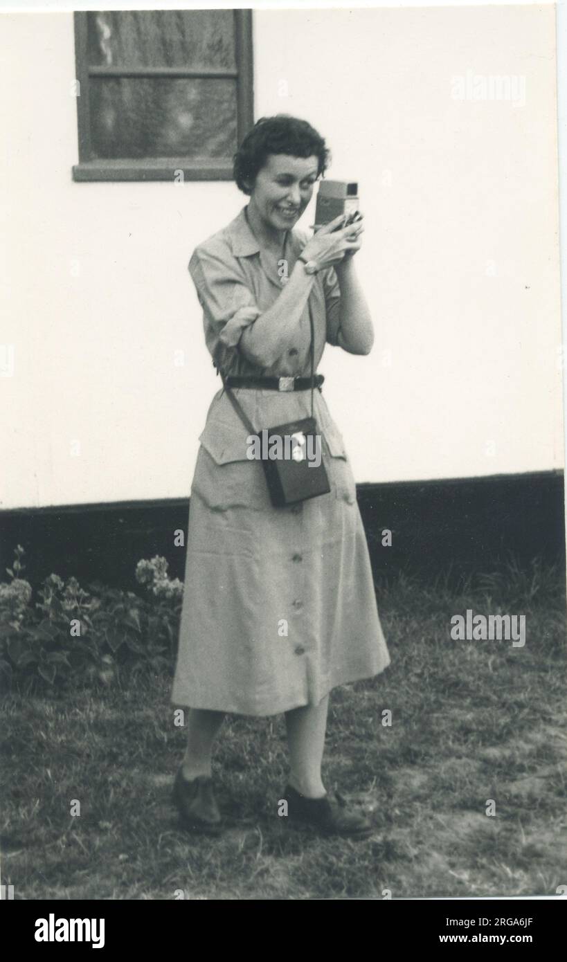 A woman using what looks to be a cine camera, probably a Bell and ...