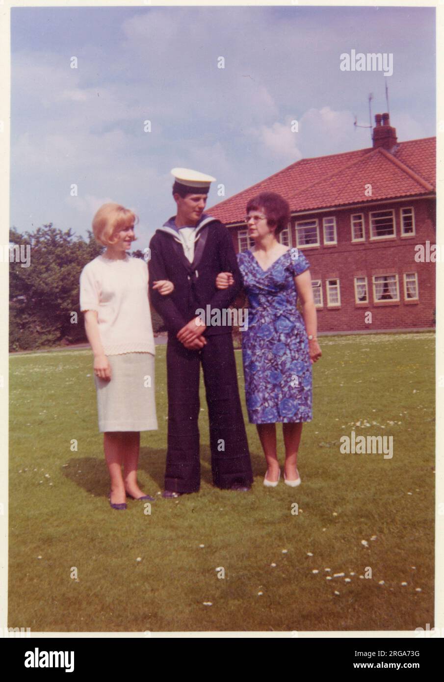 A young naval cadet (standing proudly in his sailor's uniform) is ...