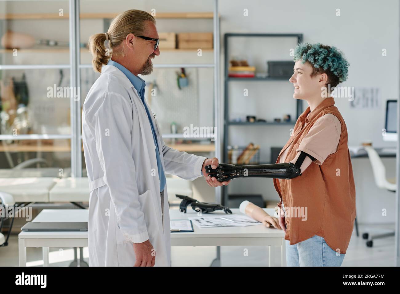 Side view portrait of young woman with bionic prosthetic arm shaking ...