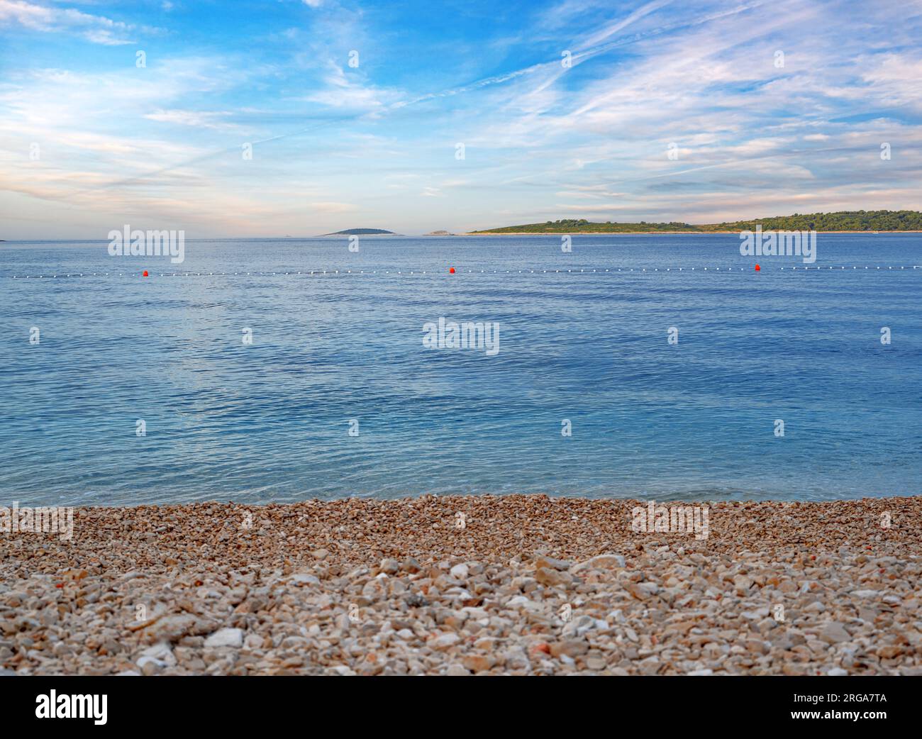 Seashore with stone pebbles, blue sky Stock Photo - Alamy