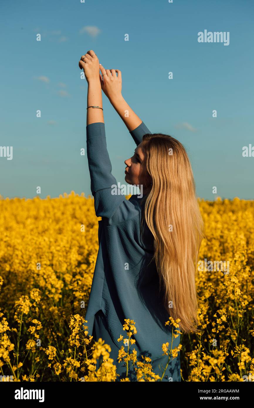 Professional model posing in a rapeseed field at sunset. Model's work ...