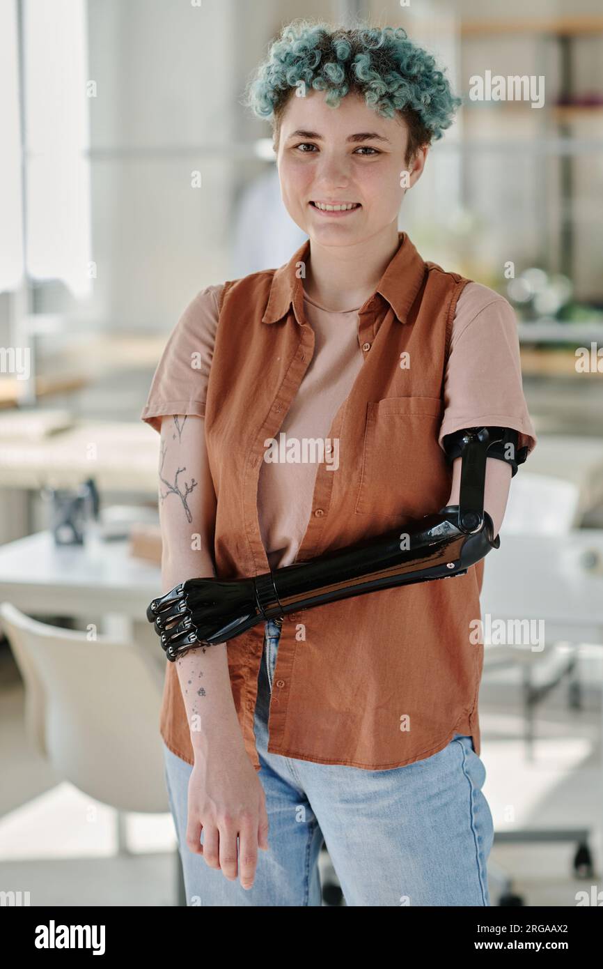 Vertical portrait of young girl with prosthetic arm and colored hair ...