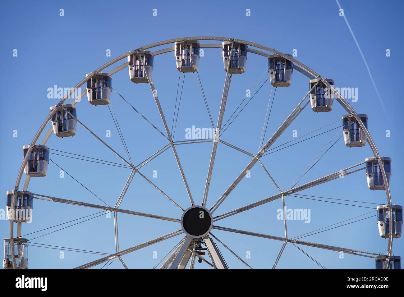 modern ferris wheel with closed cabins at carnival with blue sky no ...