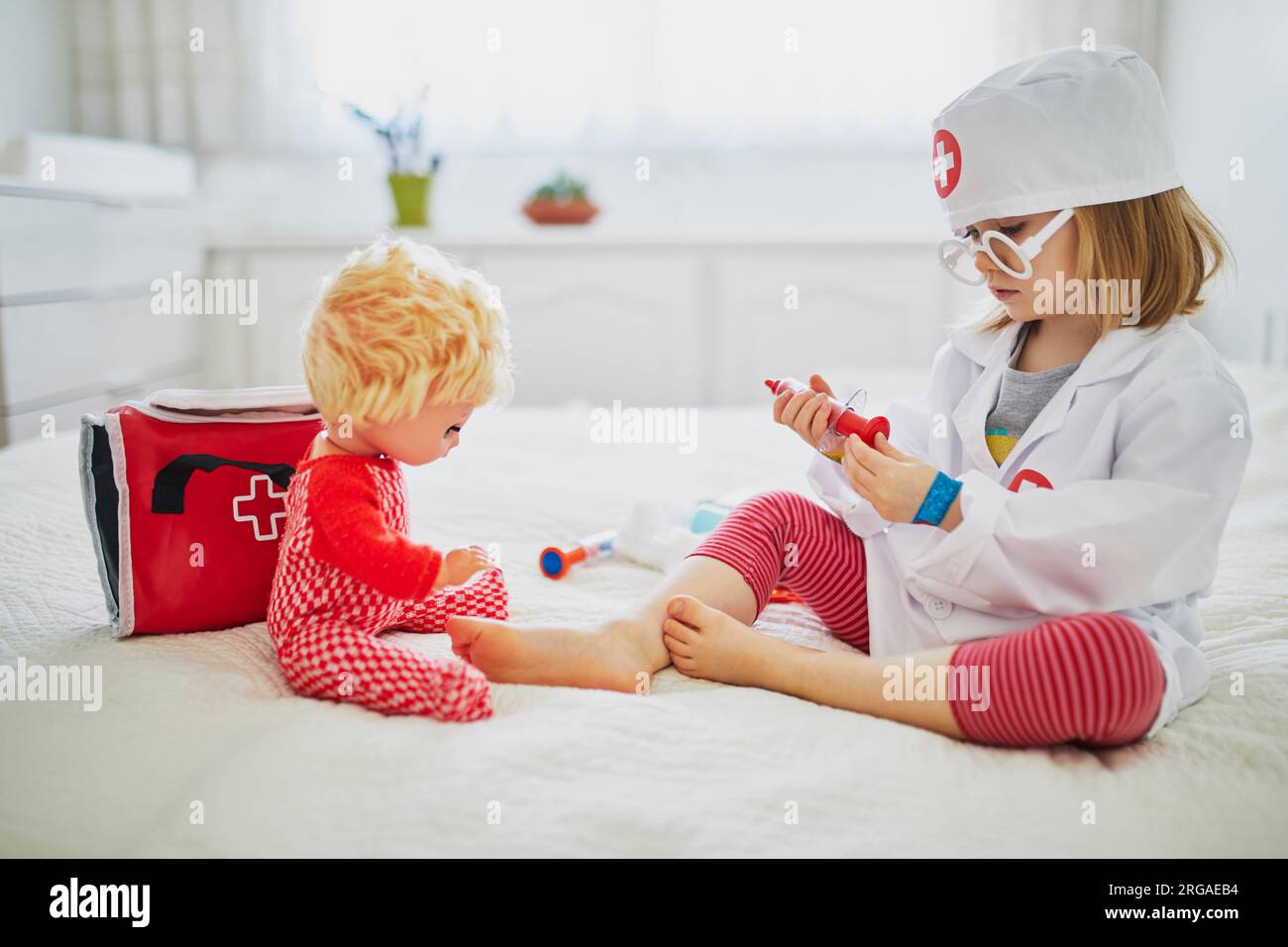 Adorable toddler girl in white coat with syringe playing doctor and ...