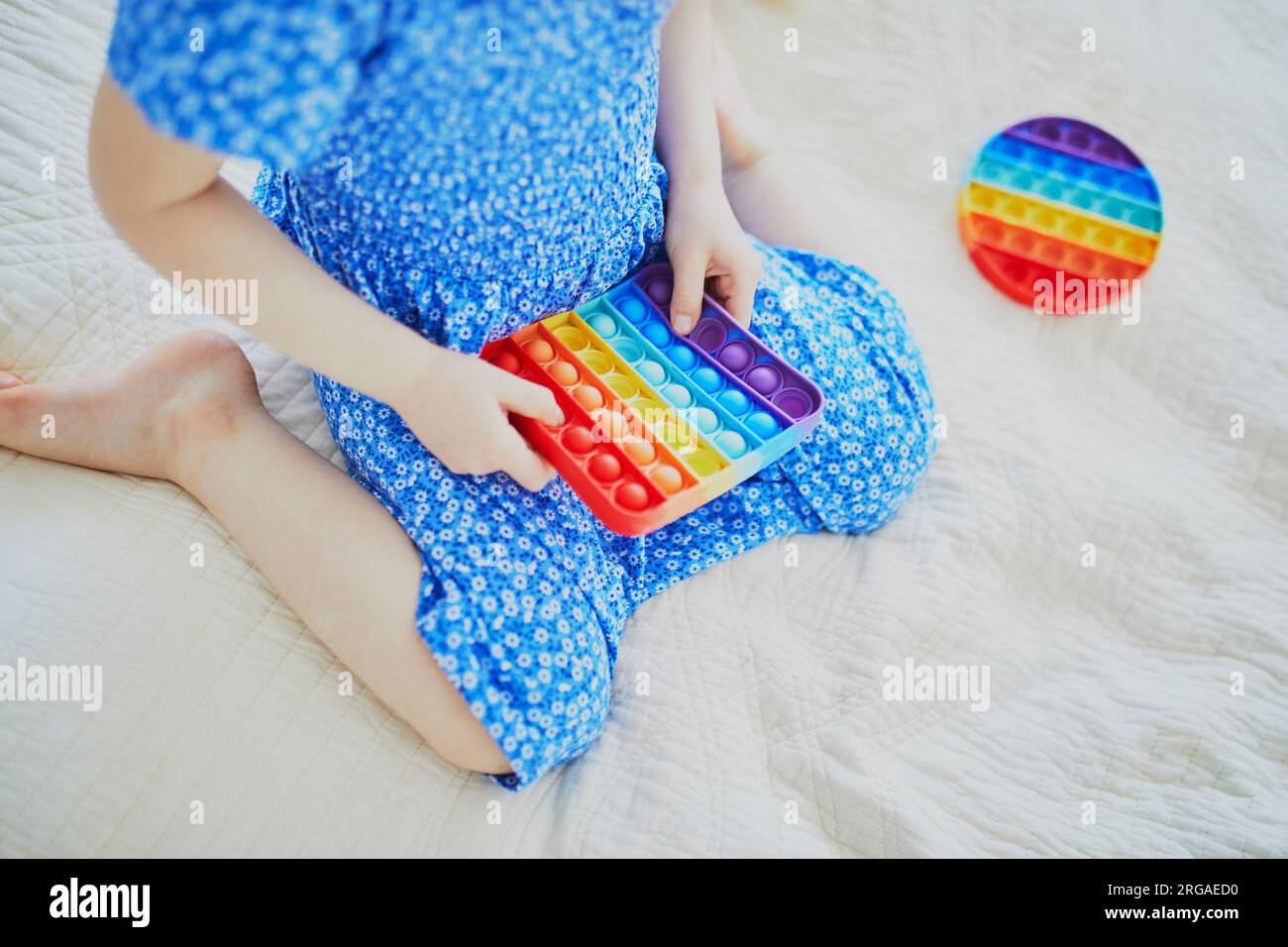 Unrecognizable little girl playing with pop it fidget. Kid playing with ...