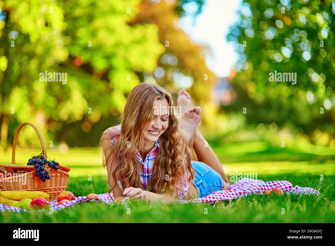 Beautiful young girl having a picnic in park Stock Photo - Alamy