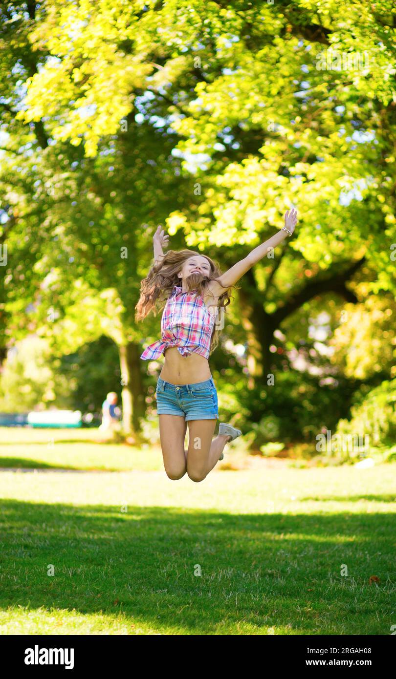 Happy girl jumping in park Stock Photo - Alamy