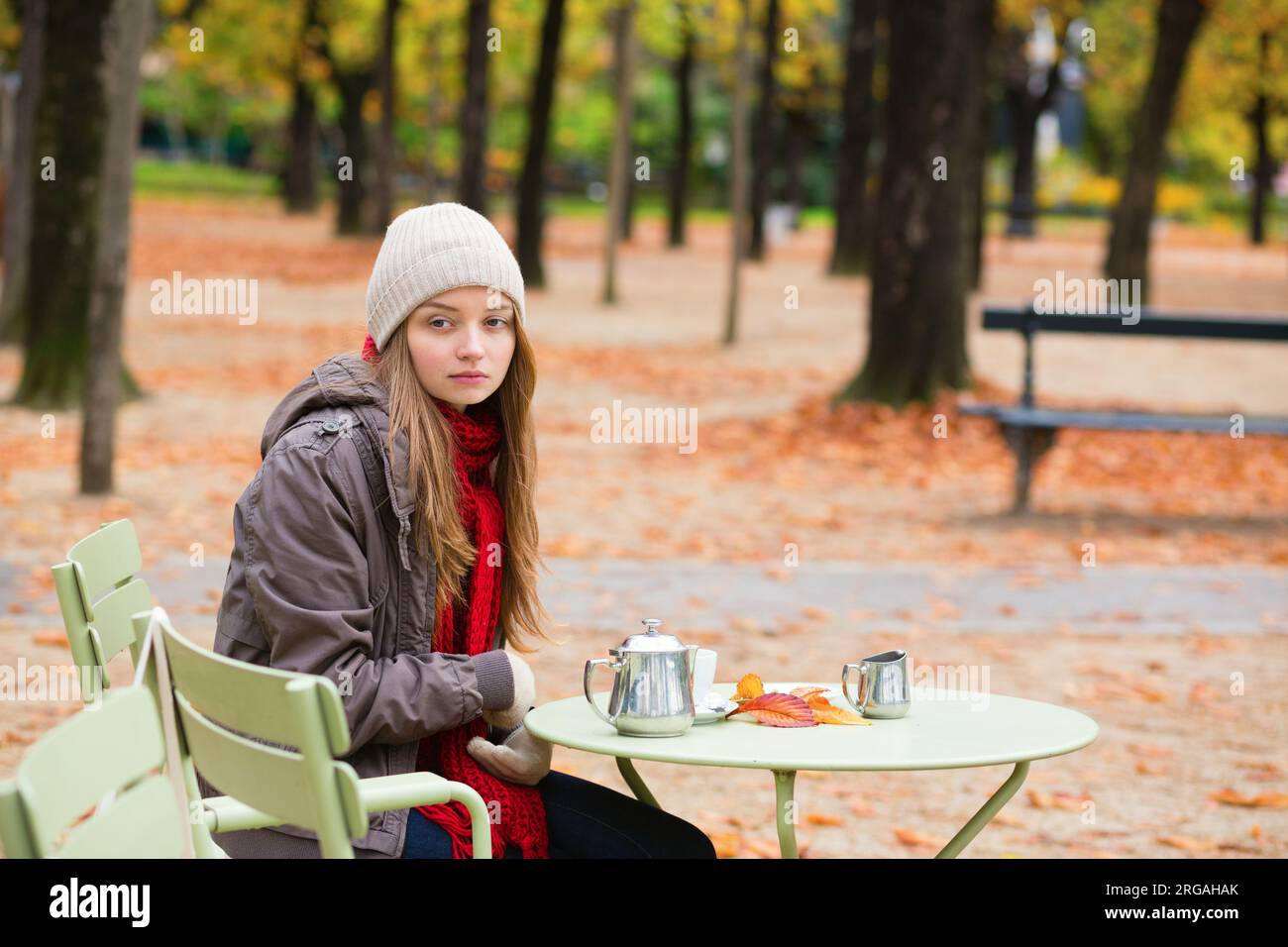 Girl drinking coffee in an outdoor Parisian cafe on a fall day Stock ...