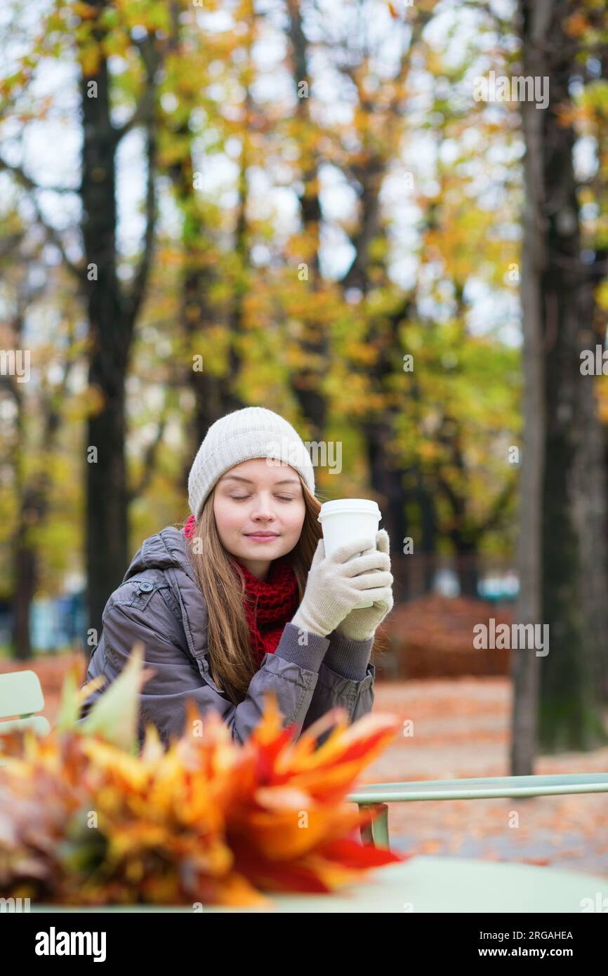 Girl drinking coffee in an outdoor Parisian cafe on a fall day Stock ...