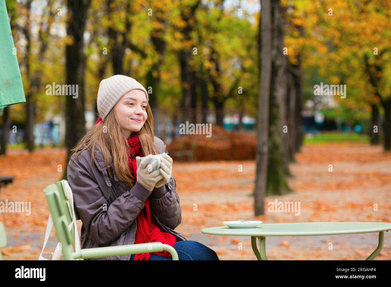 Girl drinking coffee in an outdoor Parisian cafe on a fall day Stock ...