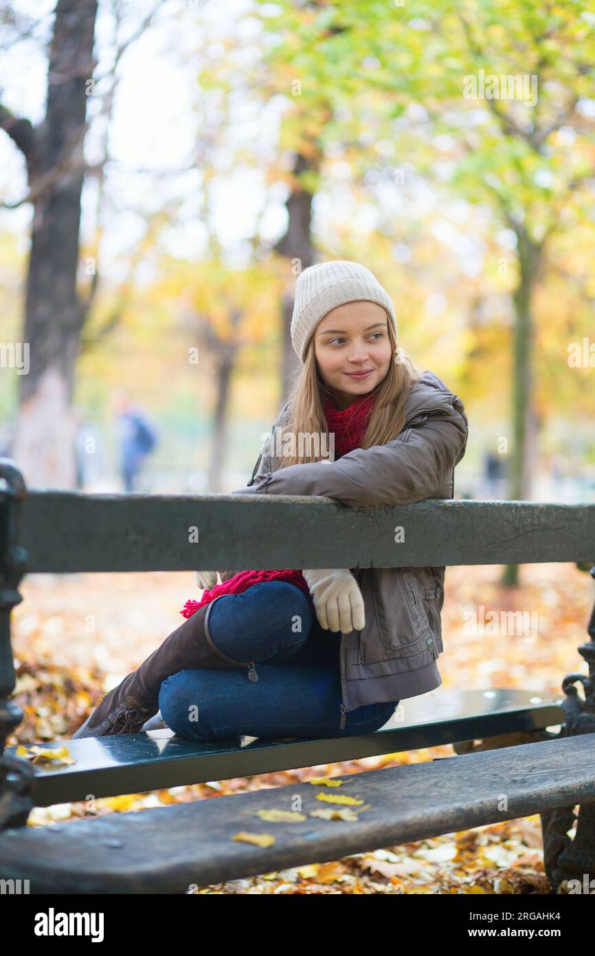 Sad girl sitting on a bench in park alone Stock Photo - Alamy