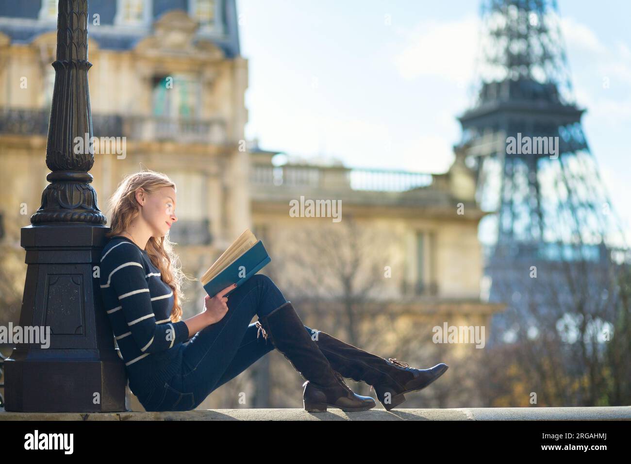 Beautiful young woman in Paris, reading a book Stock Photo - Alamy