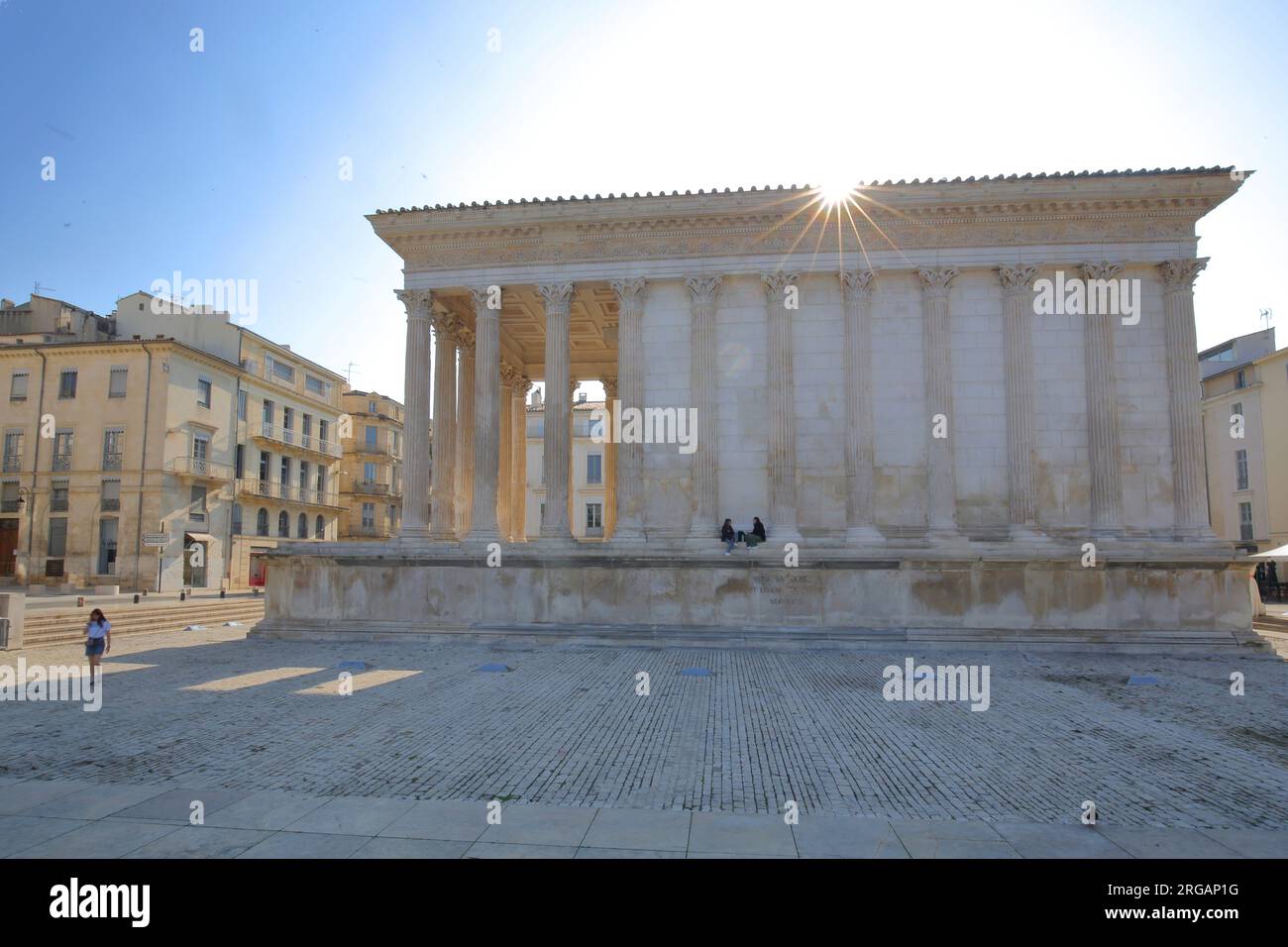 Ancient Roman UNESCO podium temple Maison Carrée with columns backlit ...