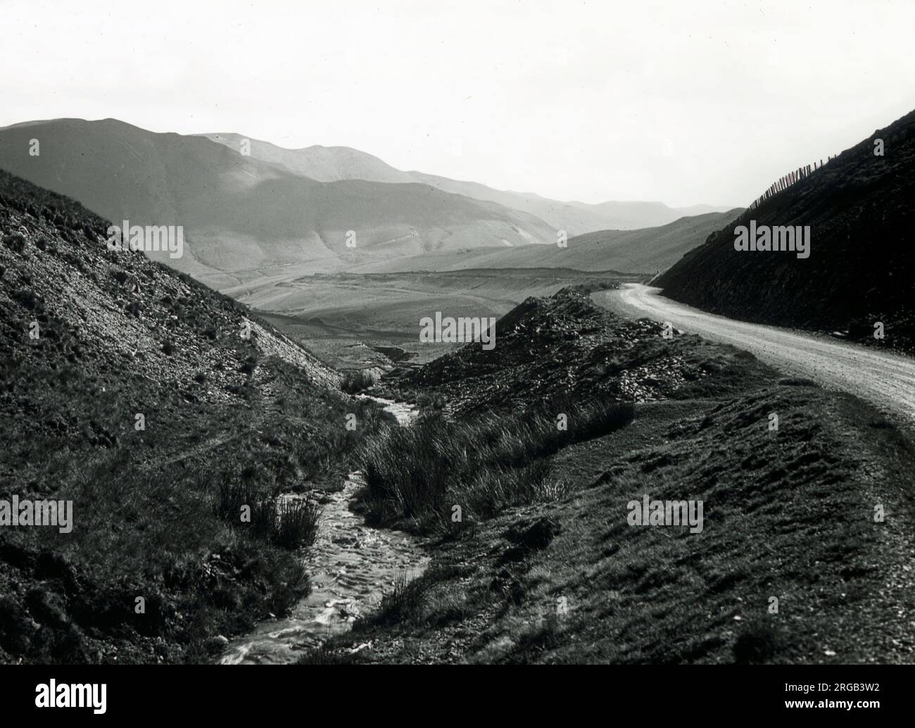 Small stream and road winding through a valley in Snowdonia National ...