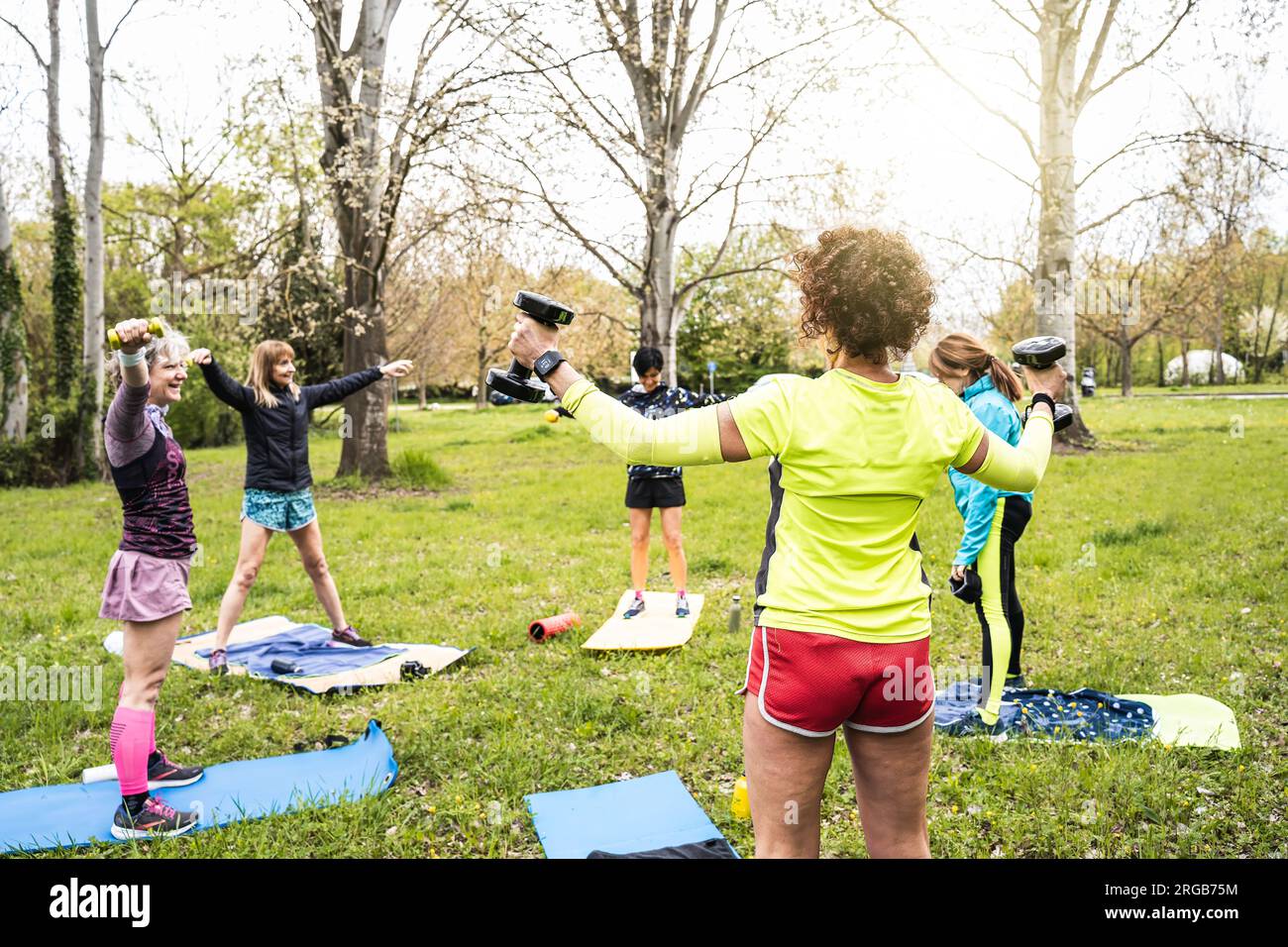 Women doing workout exercises outdoor with dumbbells - Healthy ...