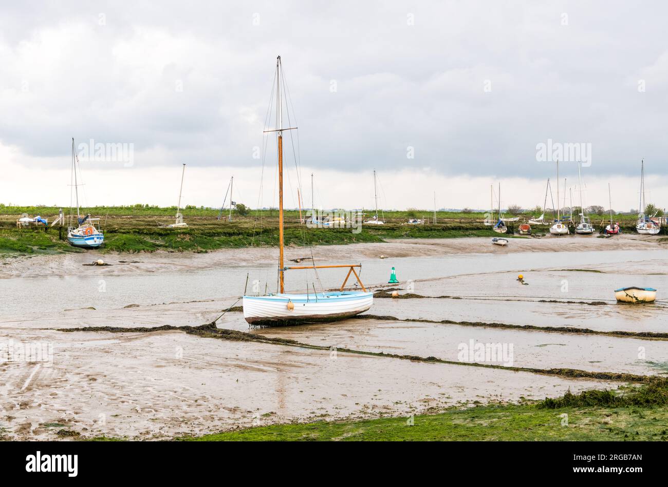 Boats at low tide in the Tollesbury Wick Nature Reserve, near Maldon ...
