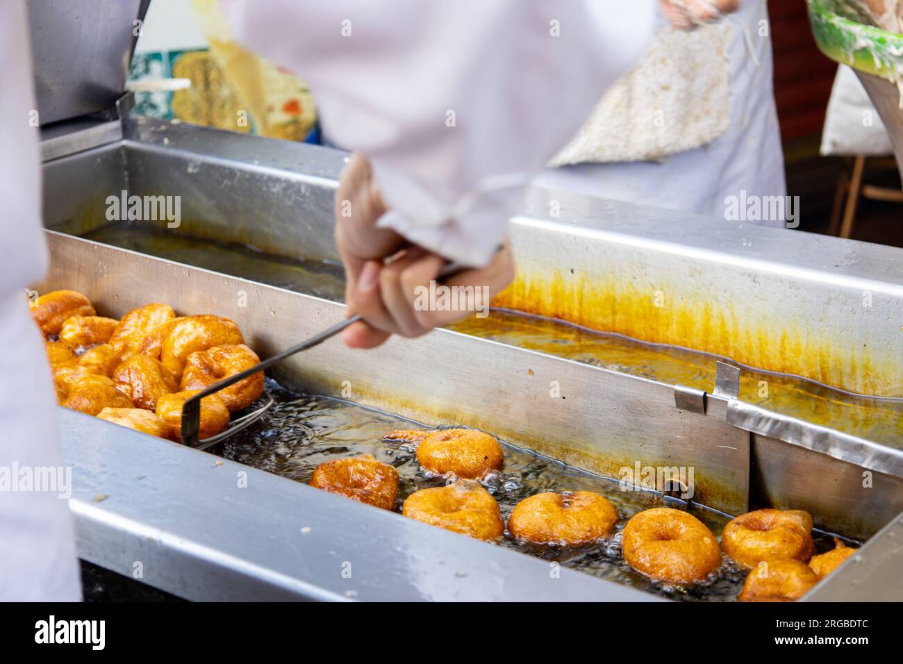 Cooking Valencian donuts. Frying traditional Spanish sweet food called ...