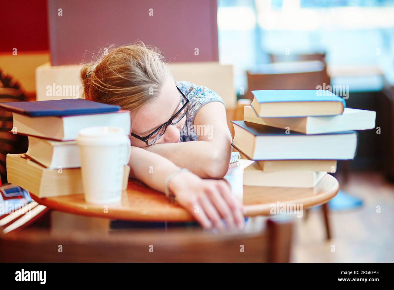 Beautiful young student with lots of books, preparing for exams in a ...