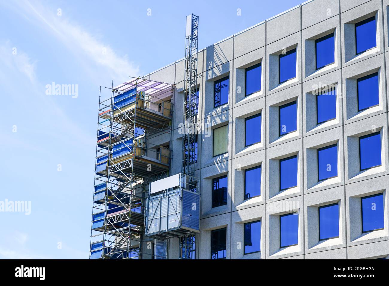 Repair works of a modern office building using portable scaffolding ...