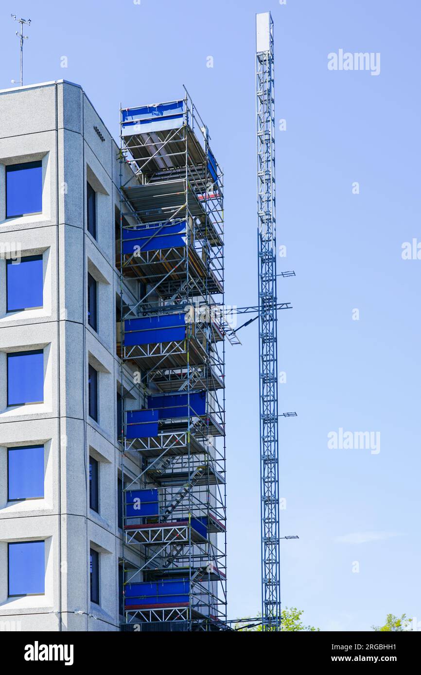 Repair works of a modern office building using portable scaffolding ...
