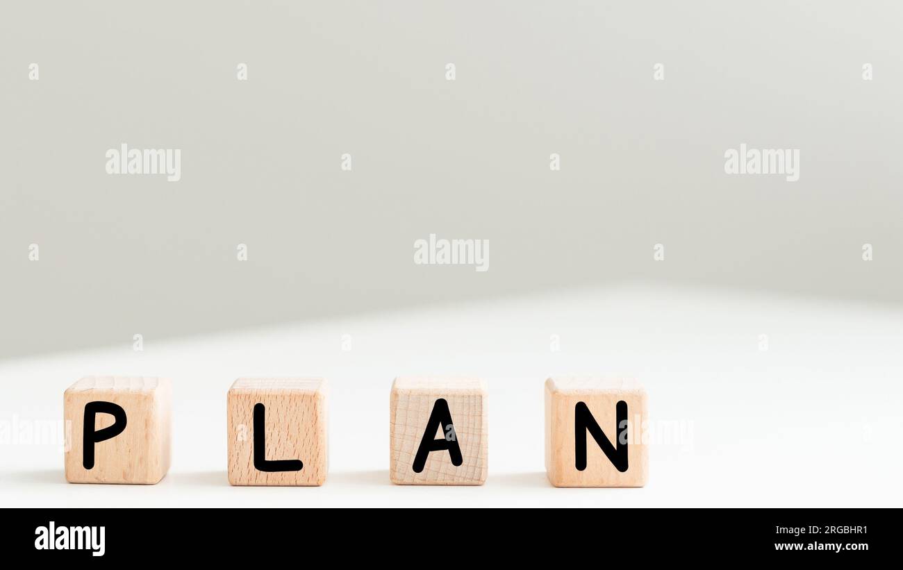 Wooden cubes with word PLANS on the office desk Stock Photo - Alamy