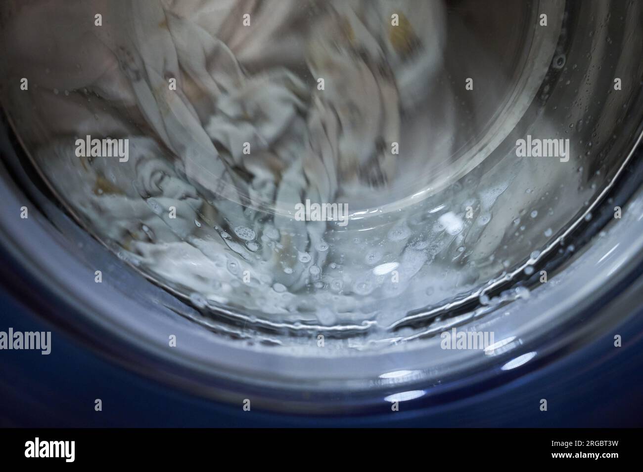 Round washing machine drum with white linen. Laundry is machine ...