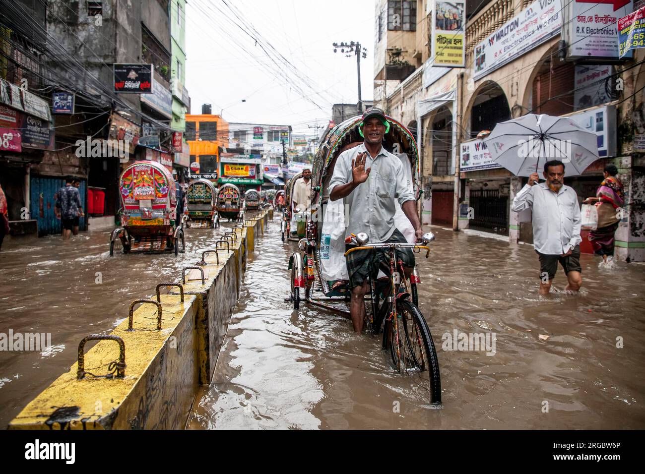 Rickshaws, vans, cars and bicycles push through waist-deep water at ...
