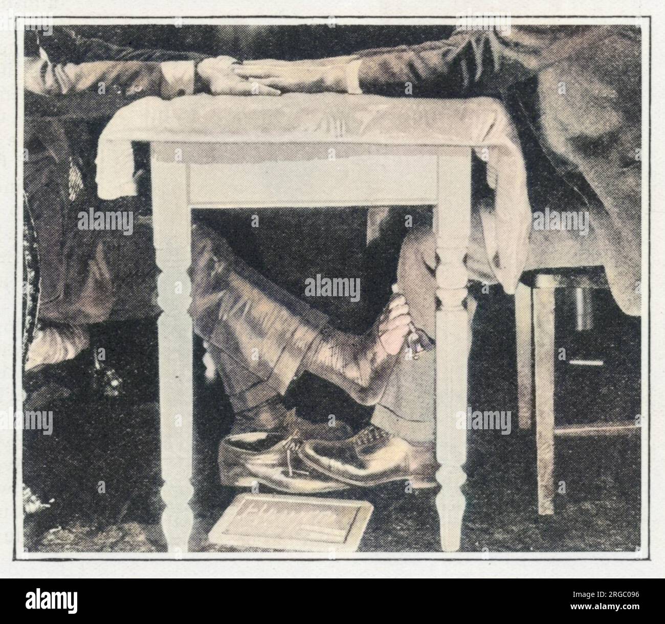 Houdini demonstrates how a foot can be released under a seance table ...