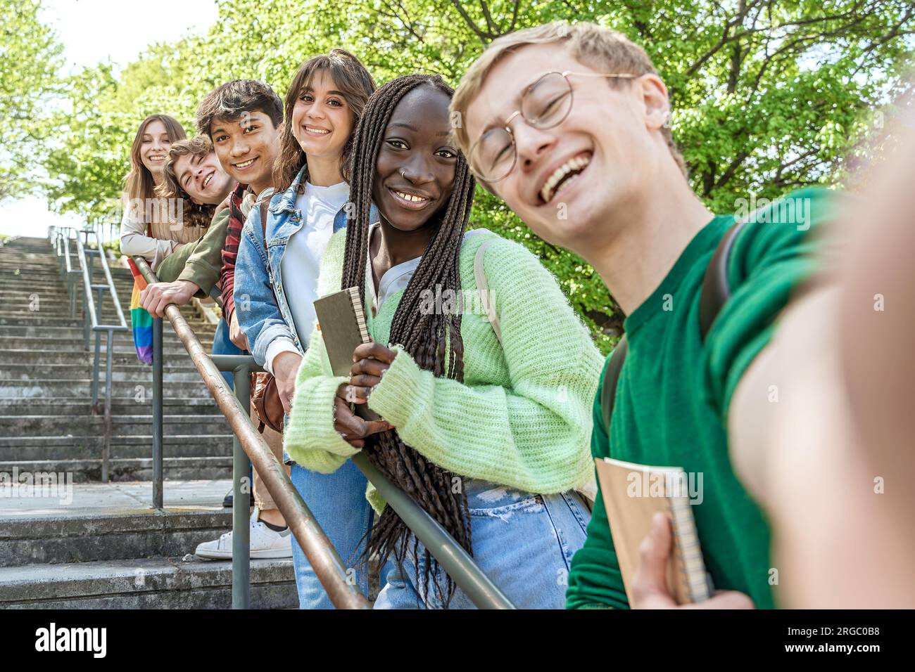Diverse group of students gather on the university campus stairs ...