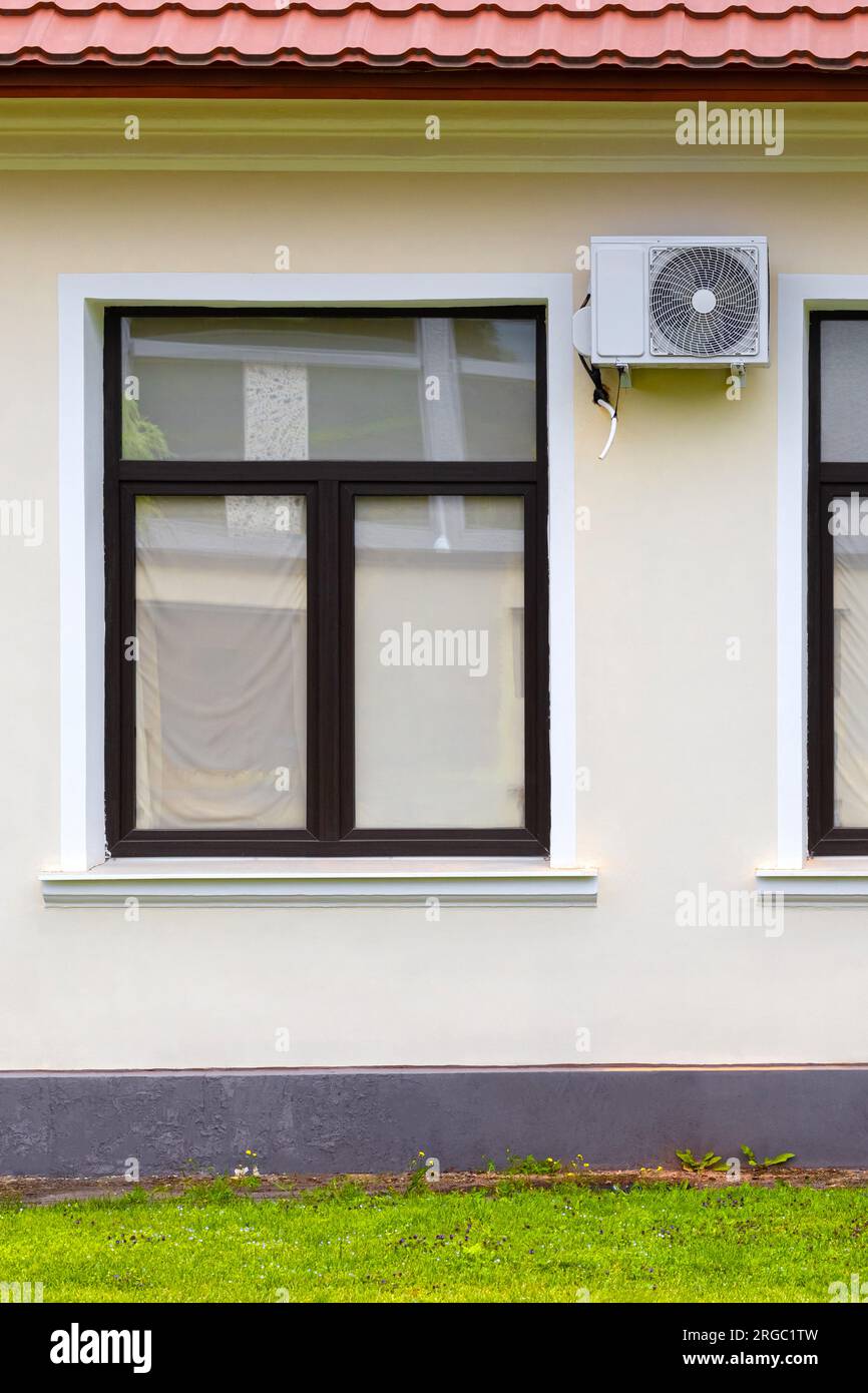 outdoor air conditioning unit installed on the facade of the house ...