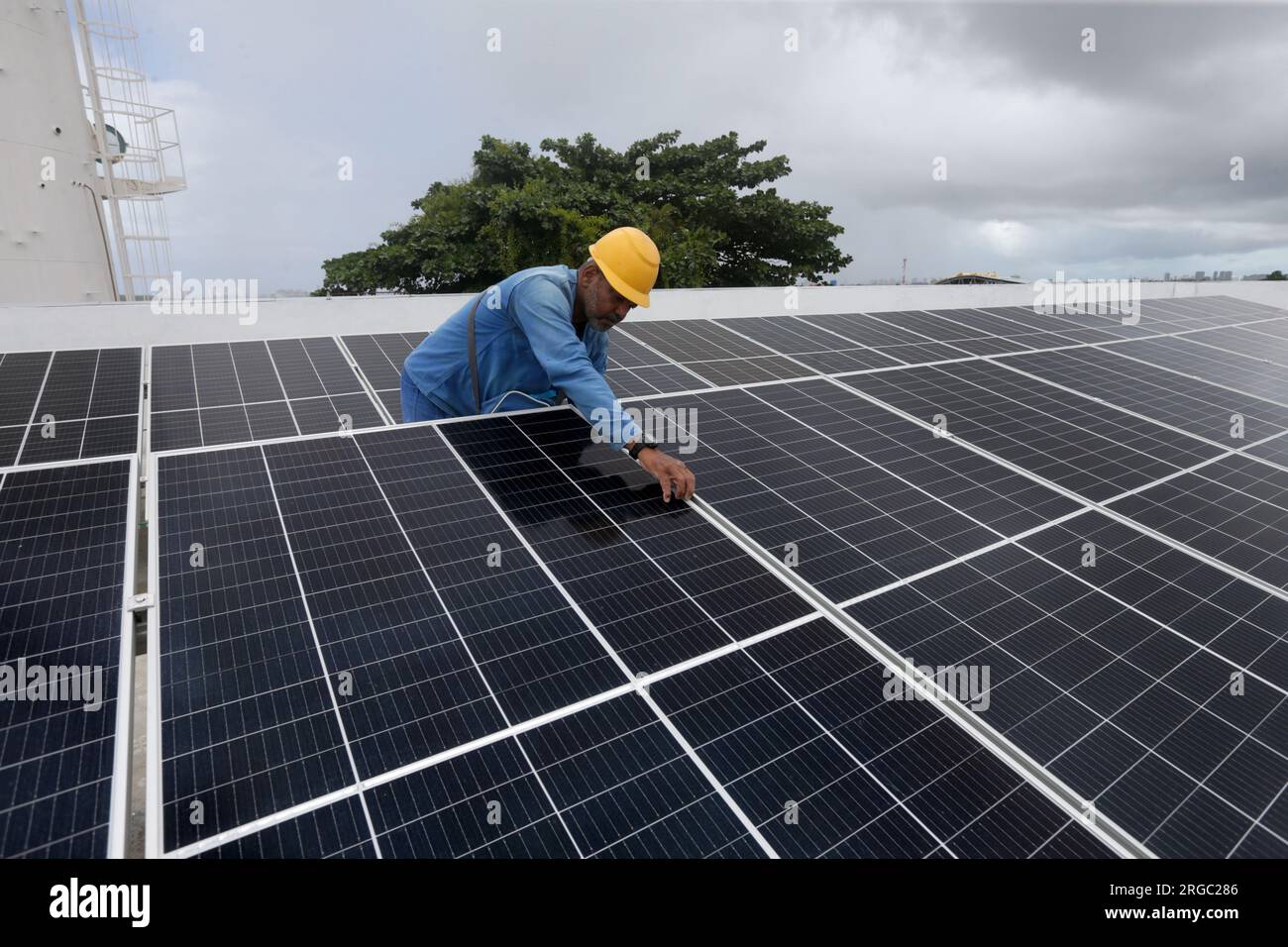 salvador, bahia, brazil - july 17, 2023: worker installs solar energy ...