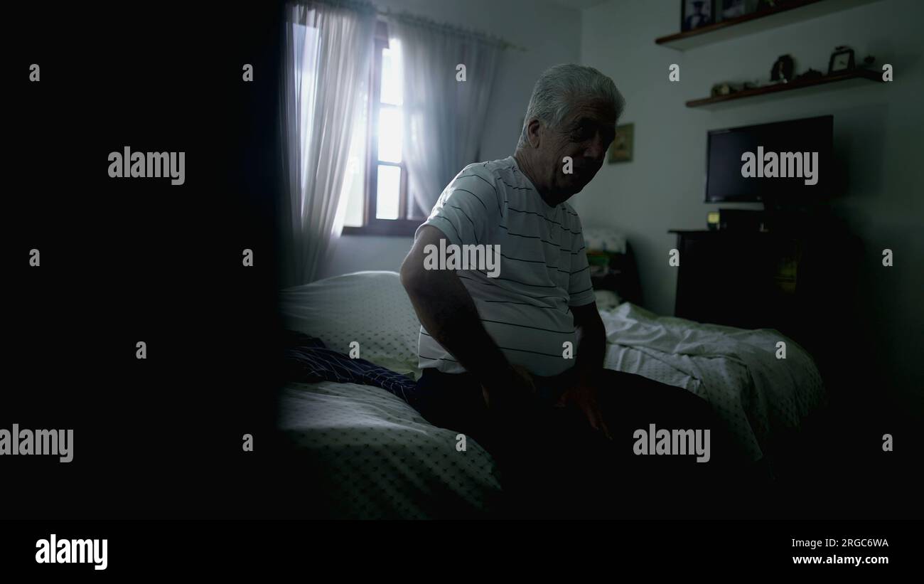 Thoughtful senior man pondering decision while sitting by bedside in ...
