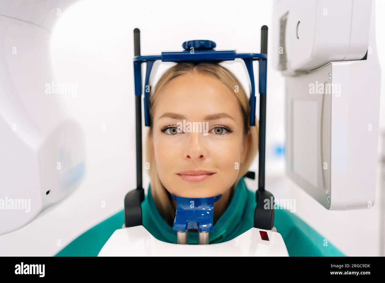 Closeup portrait of blonde female patient standing taking 3D panoramic ...