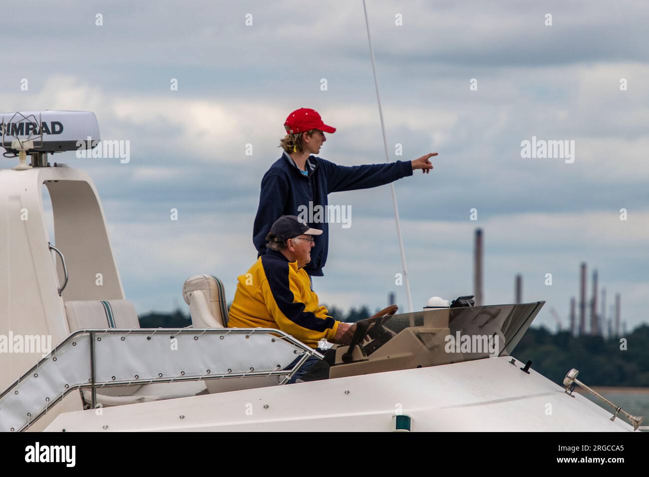 two people on the flying bridge of a luxury motor cruiser in the solent ...