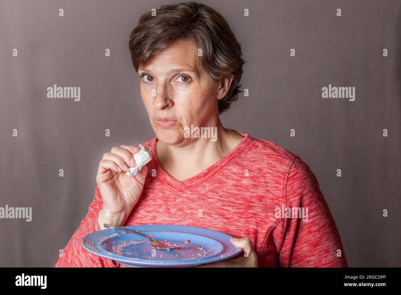 Total Guilt woman getting caught eating Stock Photo - Alamy