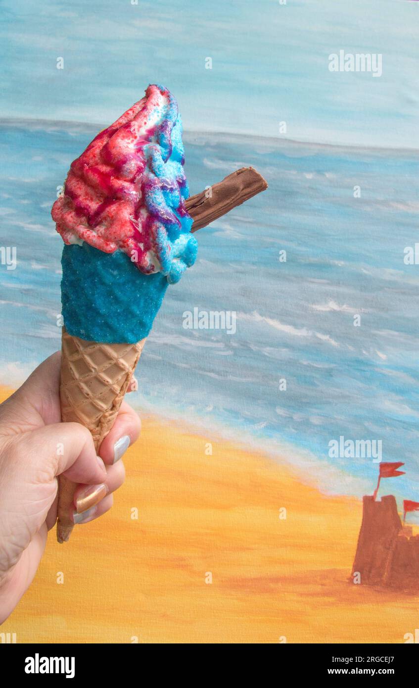 Close-up of Strawberry ice Cream melting at beach in heat Stock Photo ...