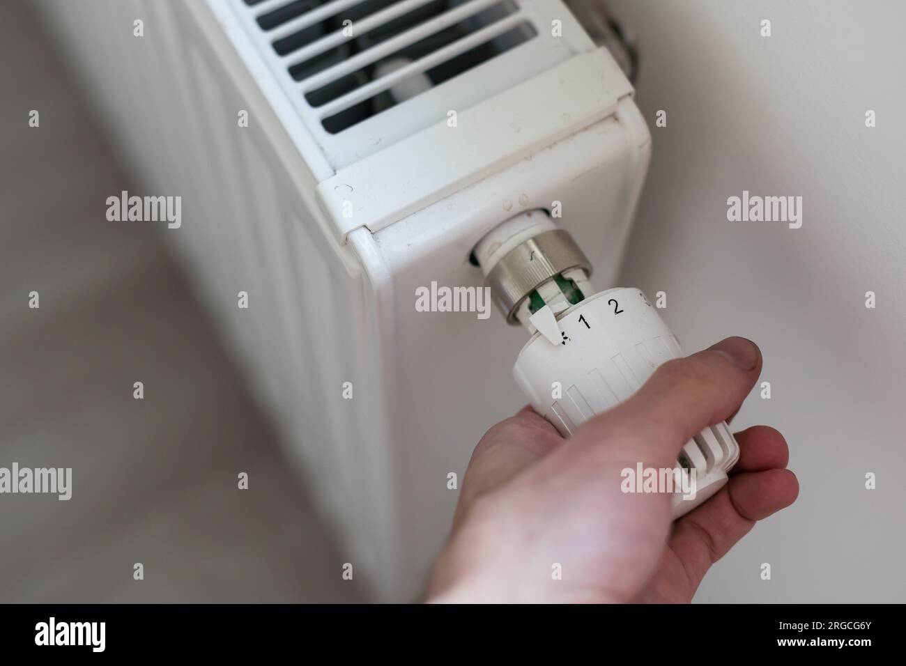Hand adjusting thermostat valve of heating radiator in a room Stock ...