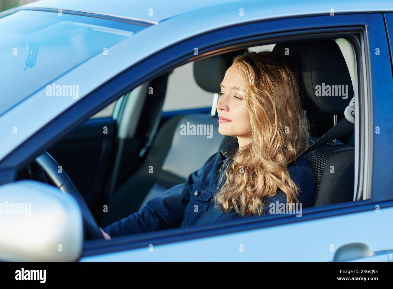 Beautiful young confident woman driving a car Stock Photo - Alamy