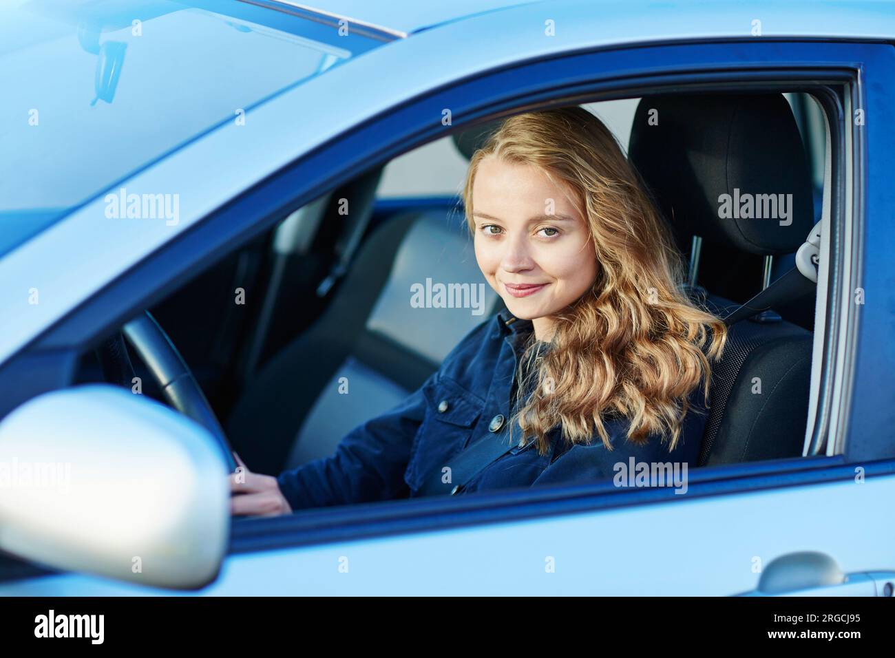 Beautiful young confident woman driving a car Stock Photo - Alamy
