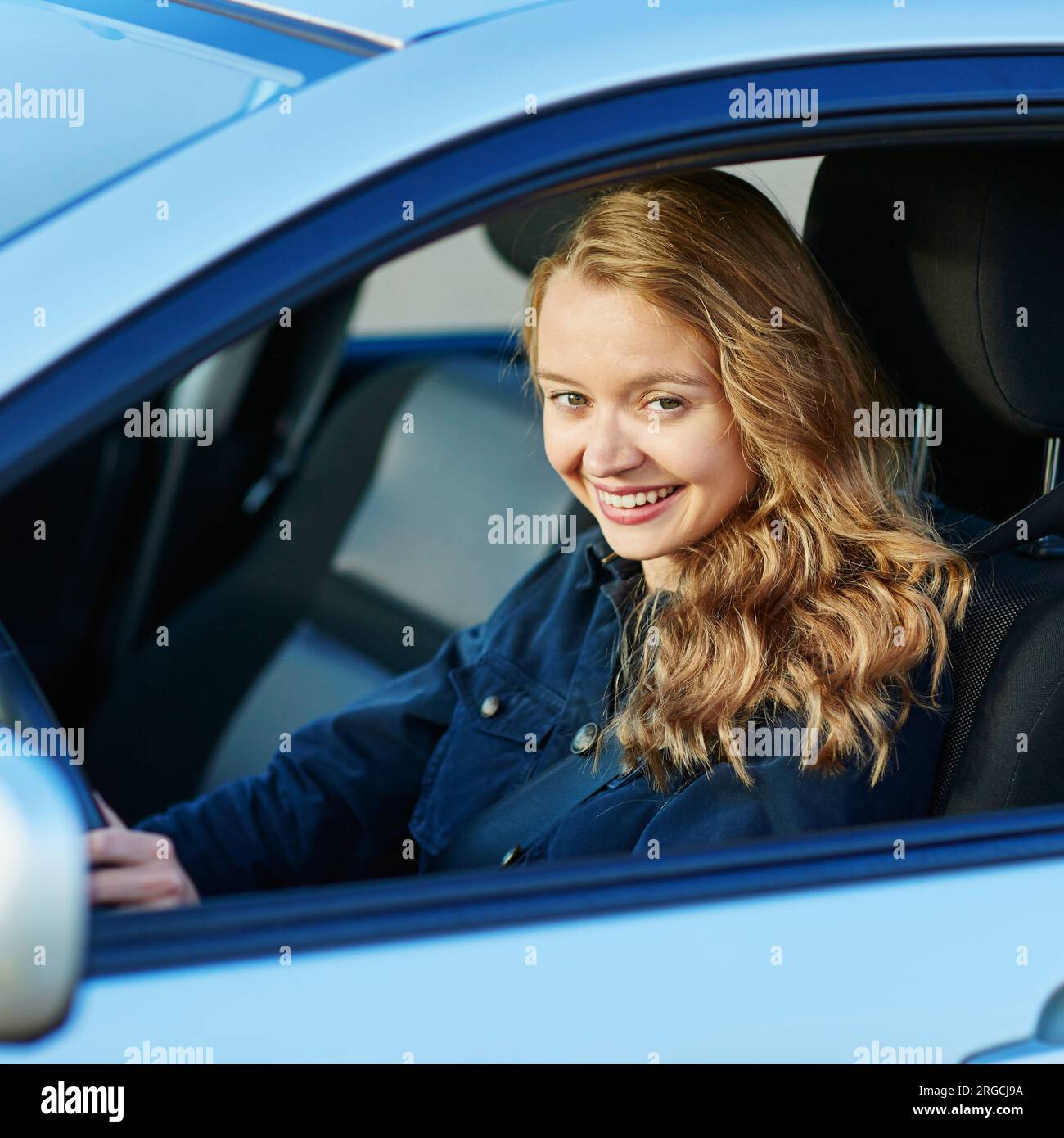 Beautiful young confident woman driving a car Stock Photo - Alamy