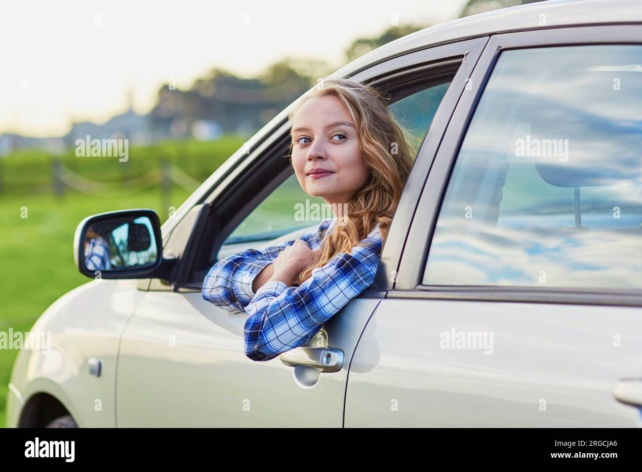 Beautiful young driver looking out of the car window Stock Photo - Alamy