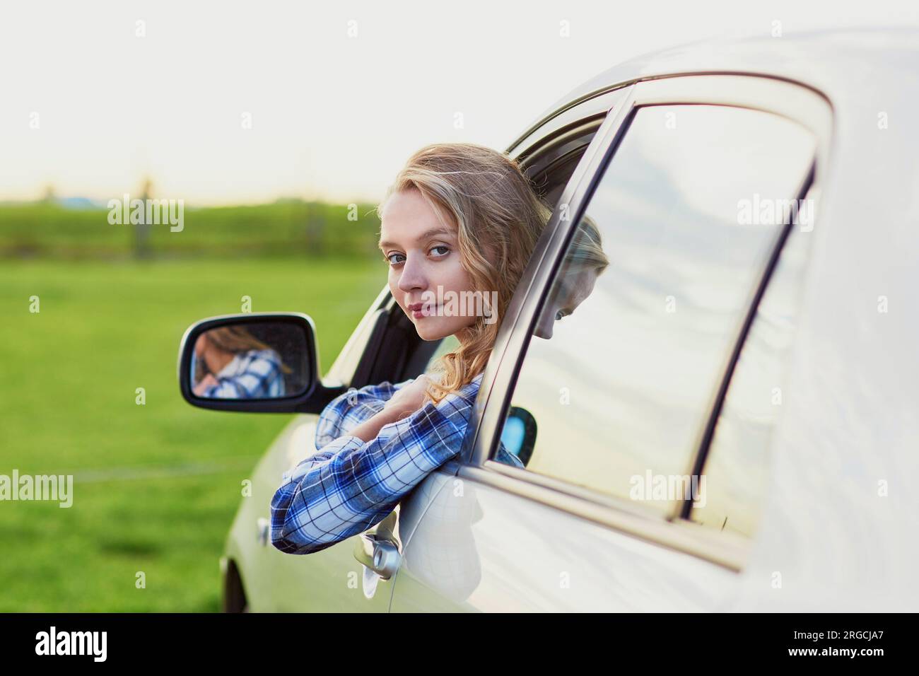 Beautiful young driver looking out of the car window Stock Photo - Alamy