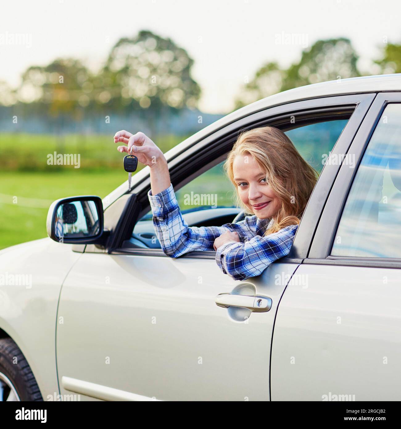 Beautiful young confident woman driving a car Stock Photo - Alamy
